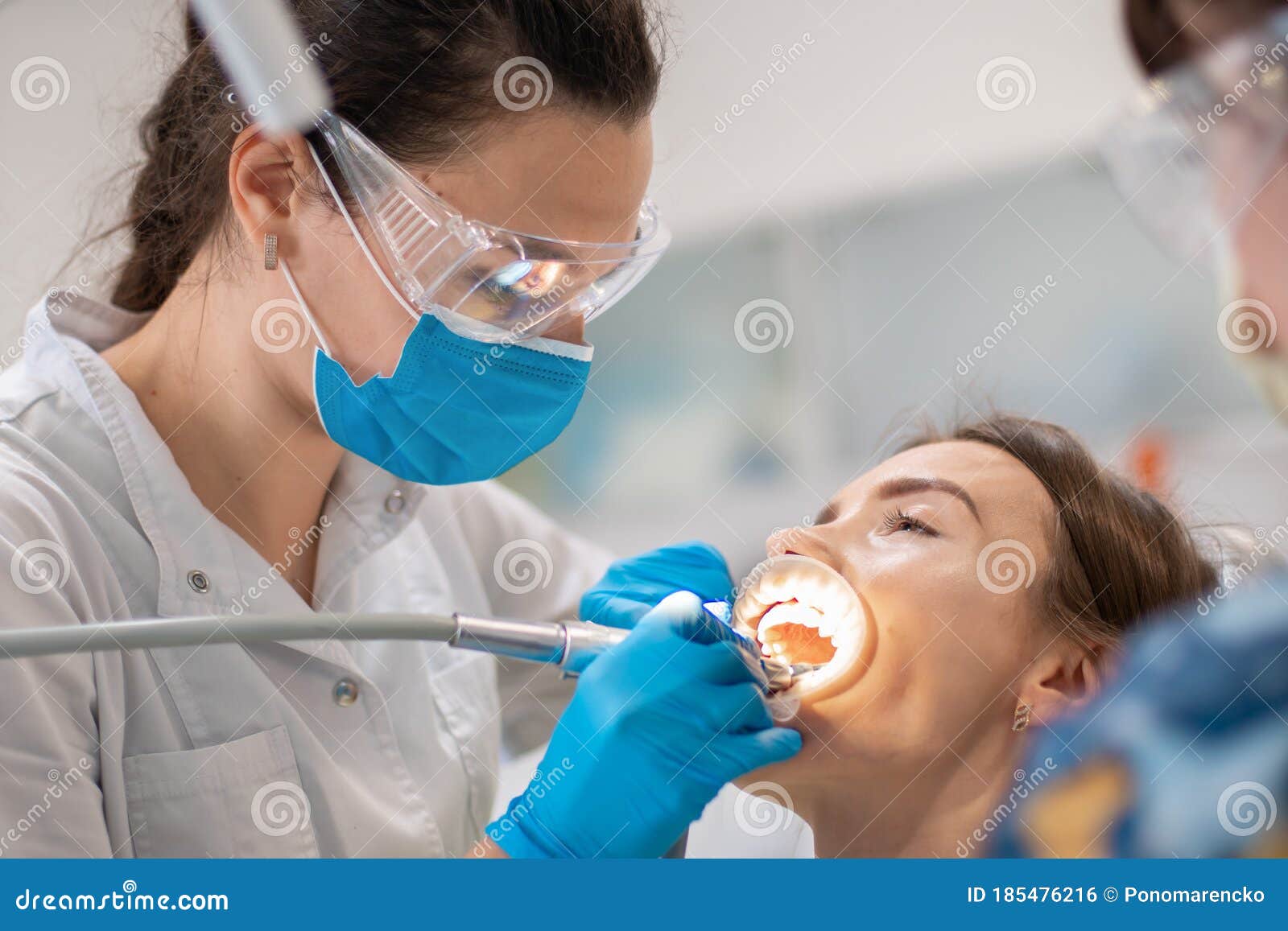 Dentista Y Asistente Tratan Los Dientes De Un Paciente Foto de archivo ...