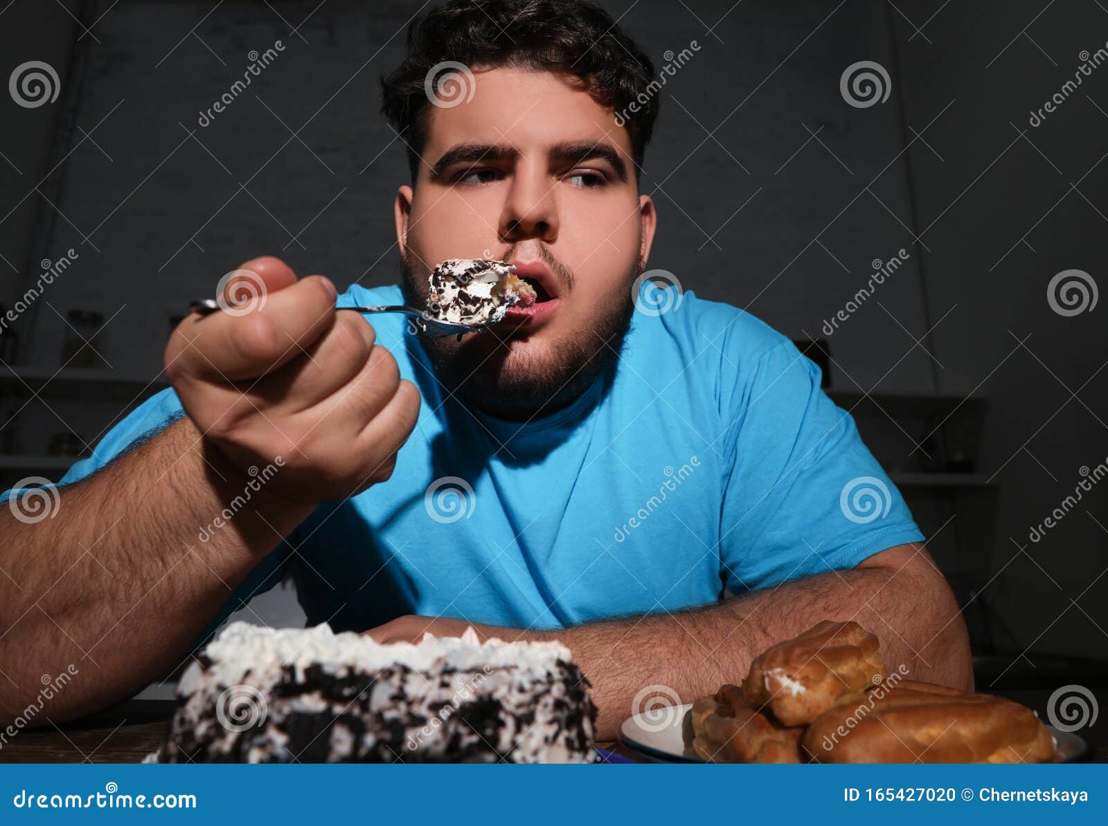 Depressed Overweight Man Eating Cake in Kitchen Stock Photo - Image of ...