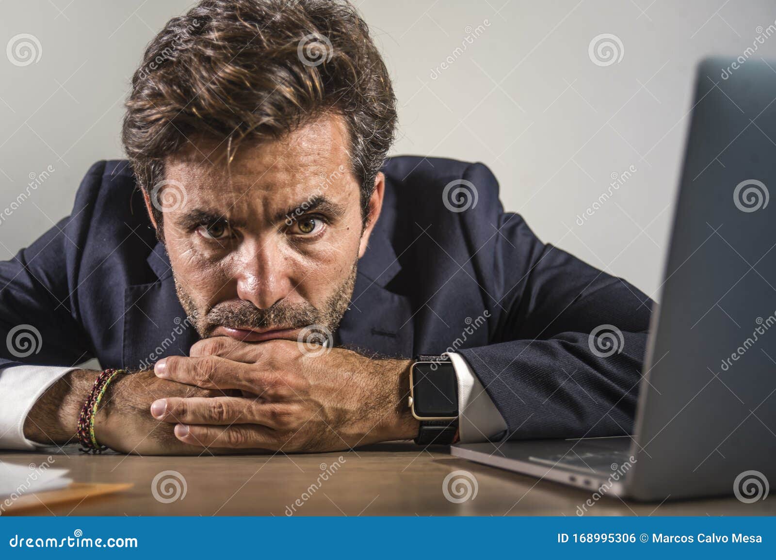 Depressed And Stressed Attractive Hispanic Businessman In Suit And Tie