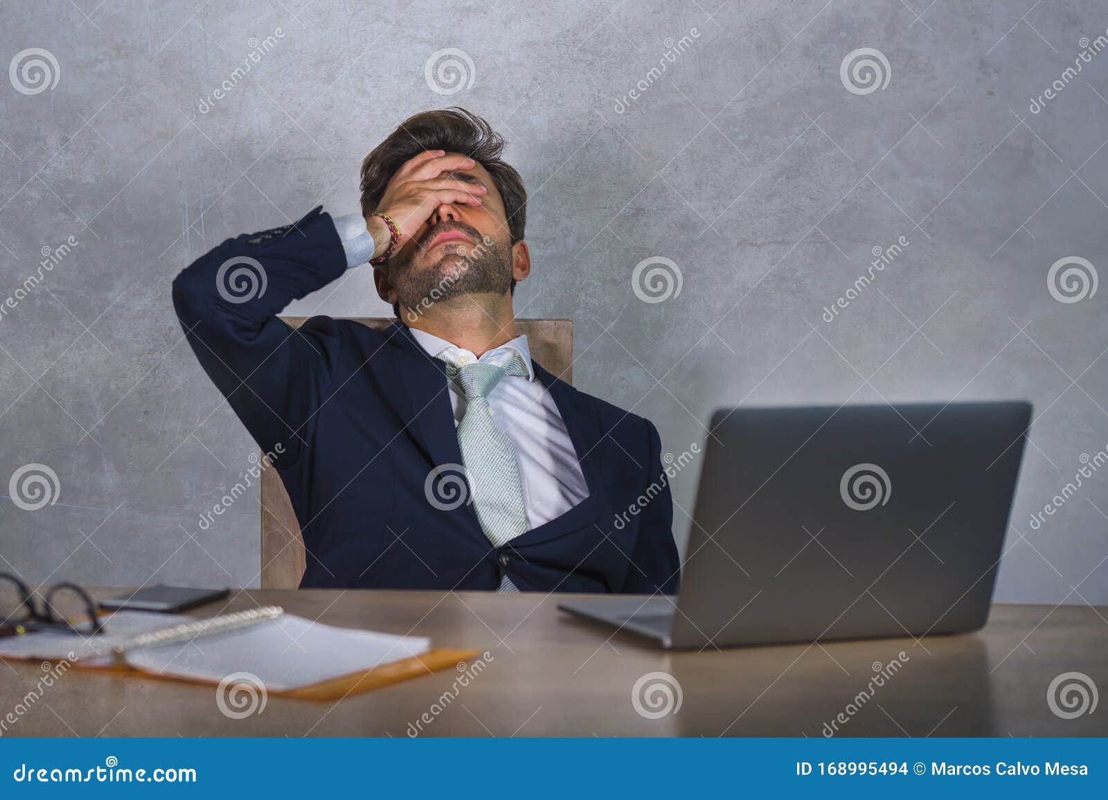 Depressed And Stressed Attractive Hispanic Businessman In Suit And Tie