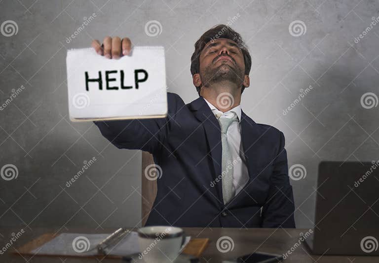 Depressed And Stressed Attractive Hispanic Man In Suit And Tie Working