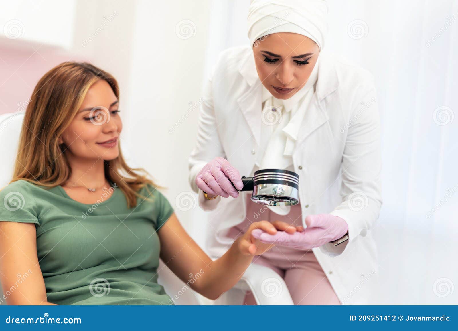 The Dermatologist Examines The Moles Or Acne Of The Patient With A