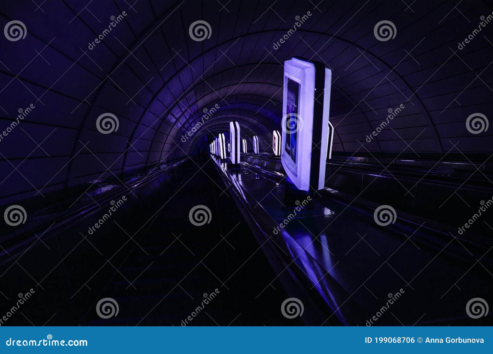 Descent On The Escalator In The Metro. Light Boxes Along The Tunnel ...