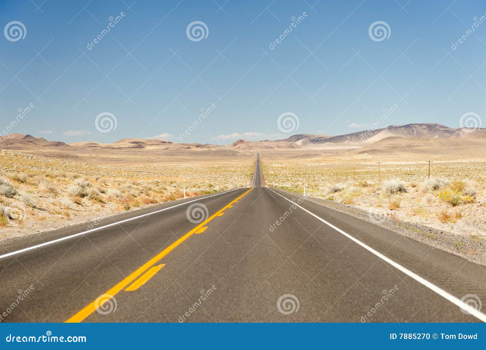 A Highway Receding To Perspective Toward A Mountain Range In A Desert ...