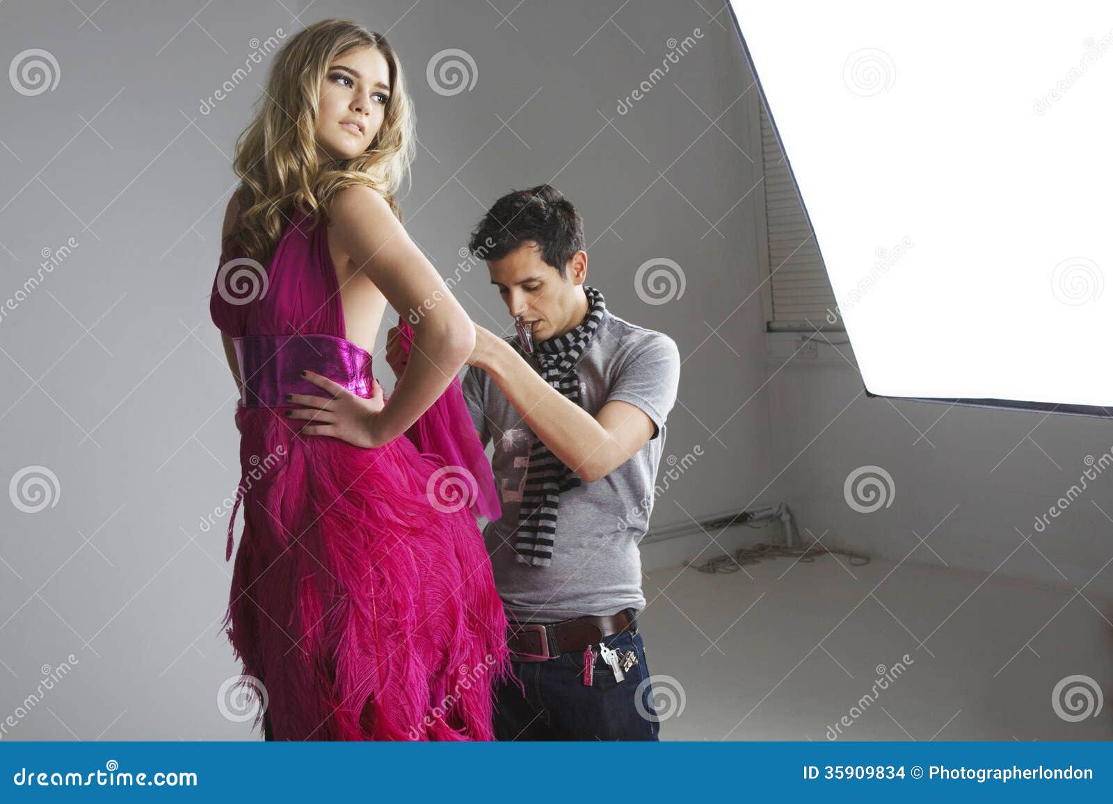 Designer Adjusting Dress on Fashion Model in Studio Stock Photo - Image ...