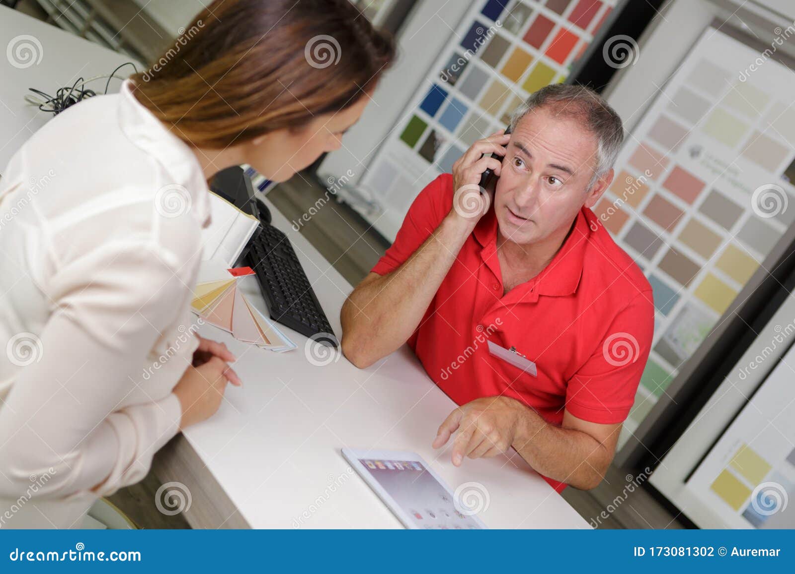 Designer with Customer Looking at Plans Calling Someone Stock Photo ...