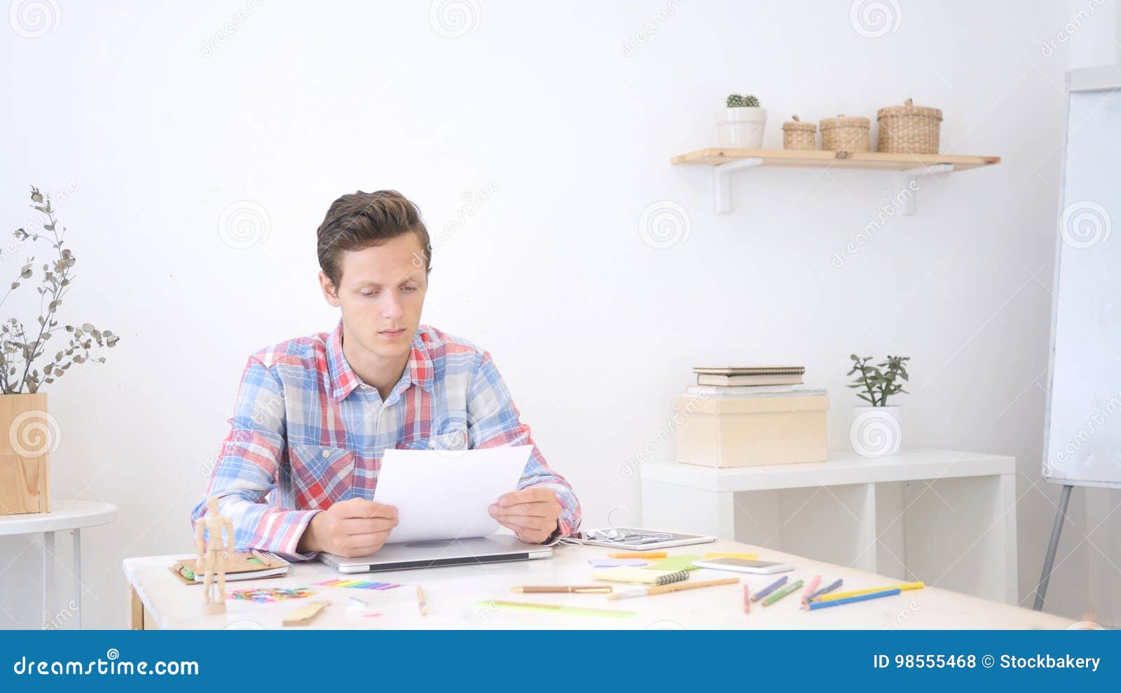 Designer Man Going through Paperwork in Office , Checking the New ...