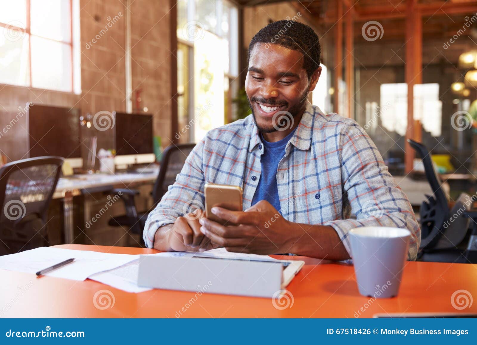 Designer Sitting at Meeting Table Texting on Mobile Phone Stock Photo ...