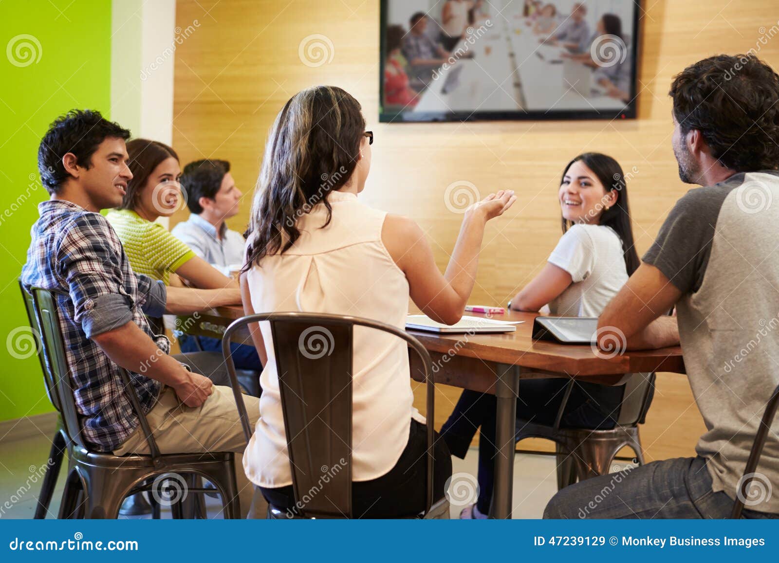 Designers Sitting Around Table in Meeting Looking at Screen Stock Image ...