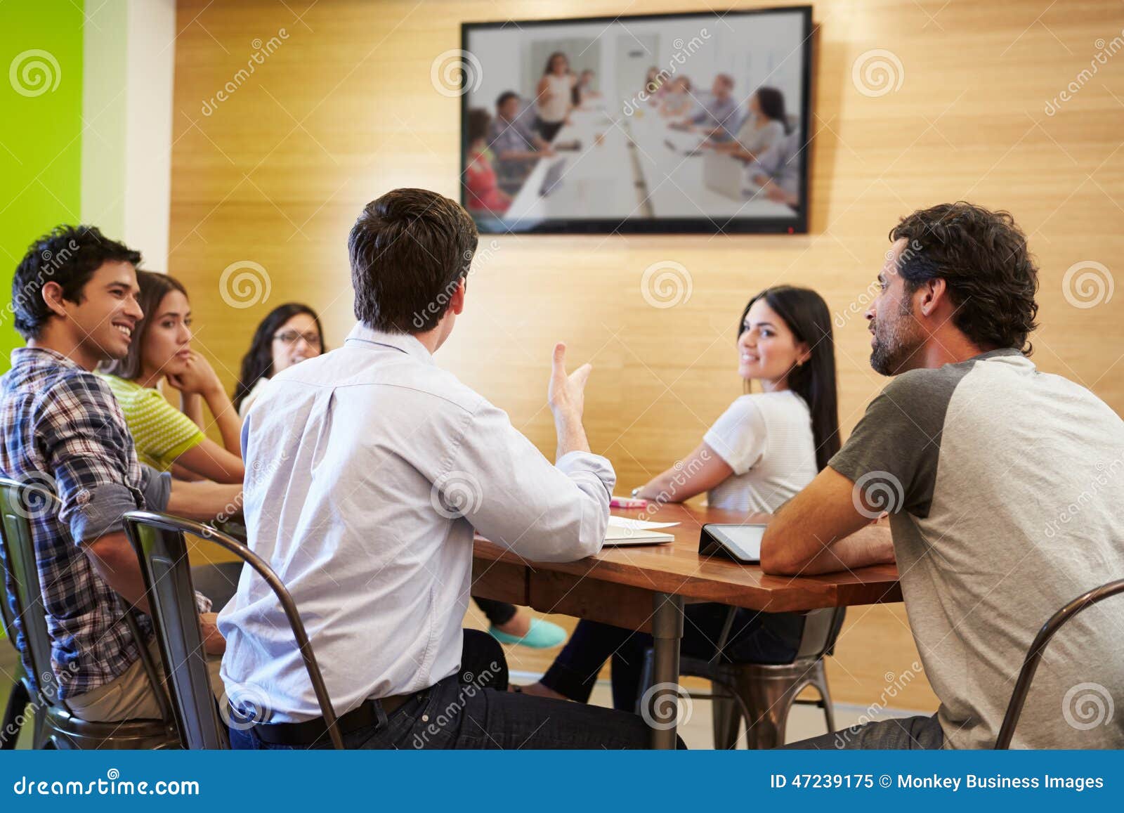 Designers Sitting Around Table in Meeting Looking at Screen Stock Image ...
