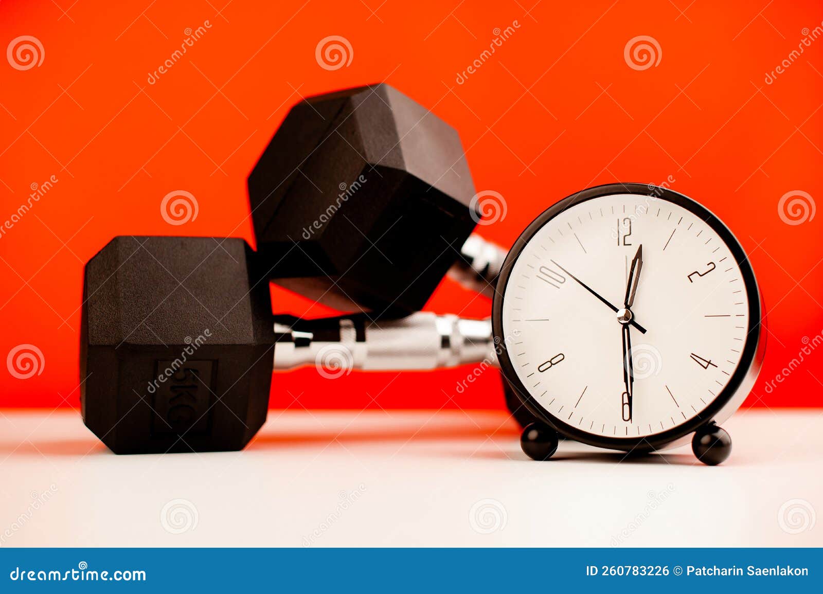 Clock on Desk Side by Side with Dumbbells for Exercise during Work Time ...