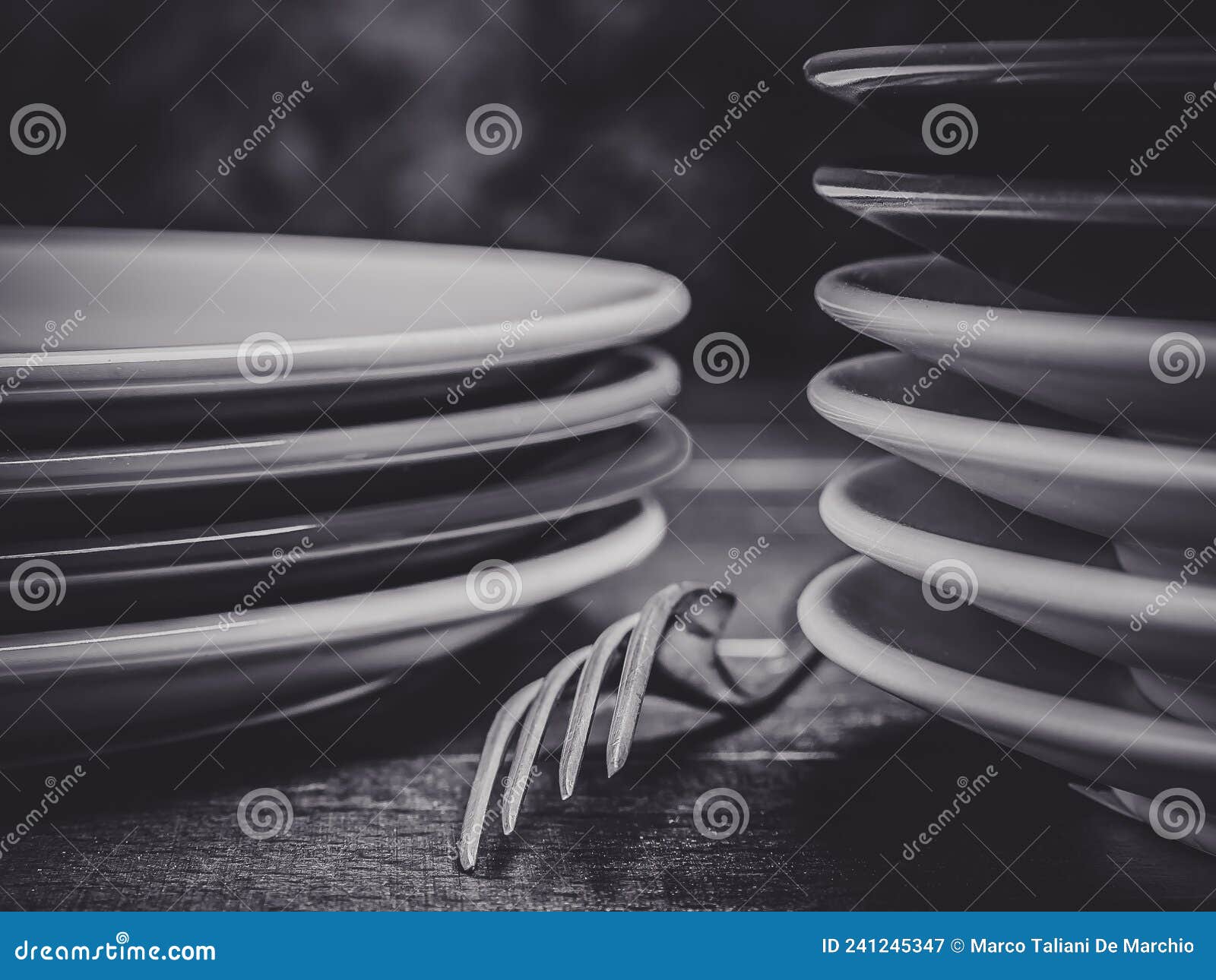 The Detail of a Fork between Two Piles of Stacked Plates, in Black and ...