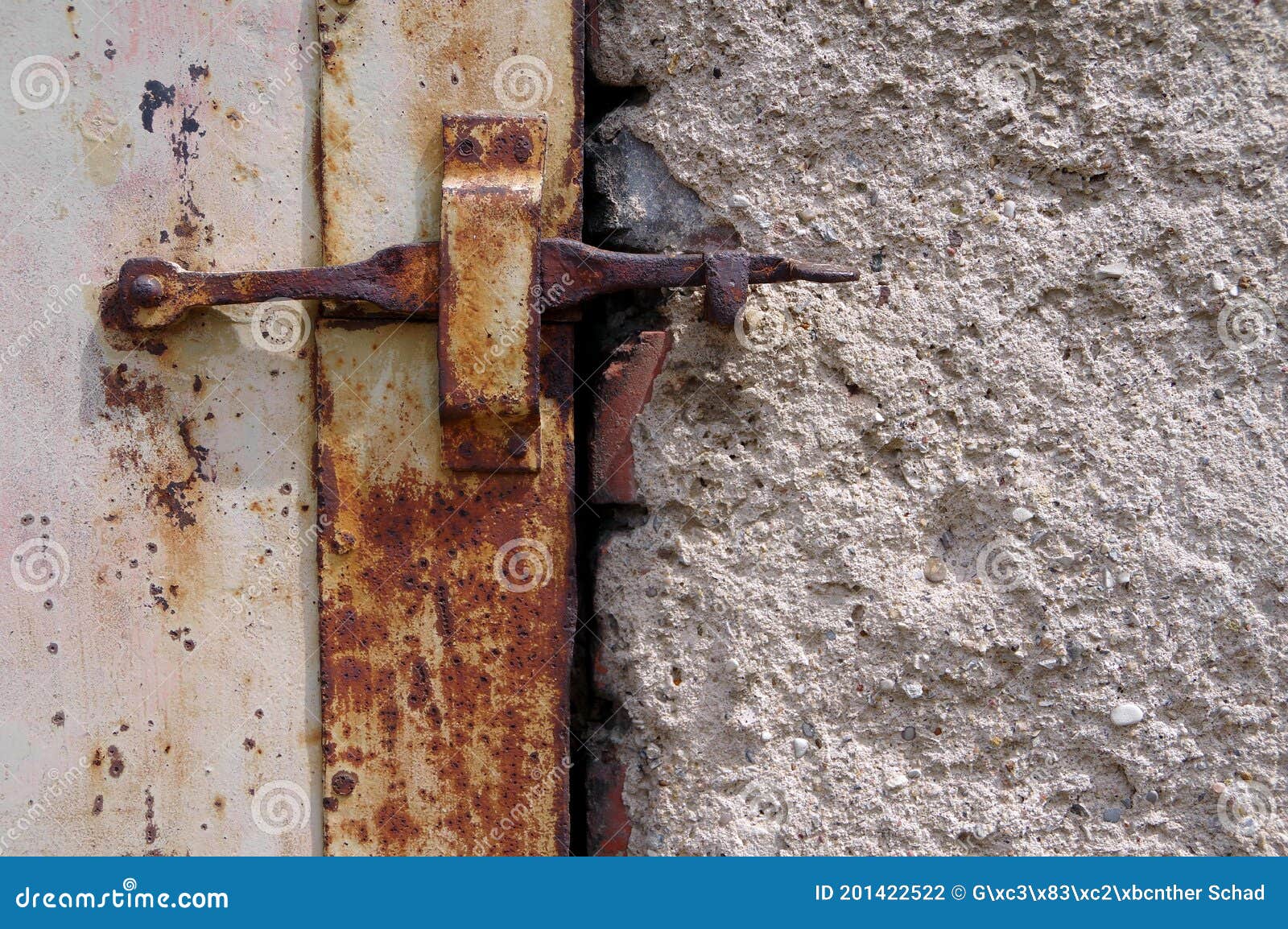 Detail of an Old Cellar Door with a Rusted Latch Next To Rough Plaster ...