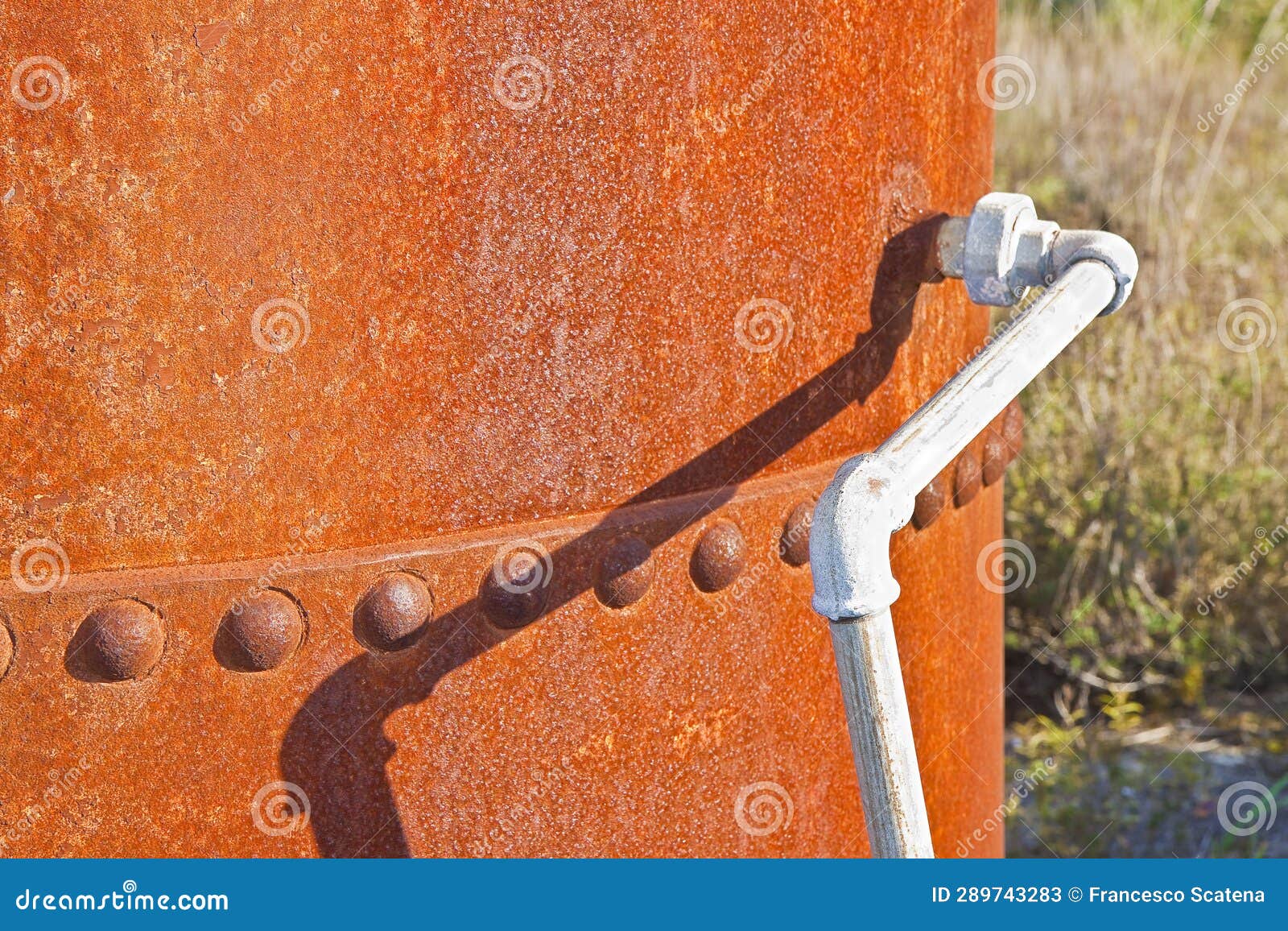 Detail of a Pipeline Against a Rusty Riveted Metal Tank Stock Image ...