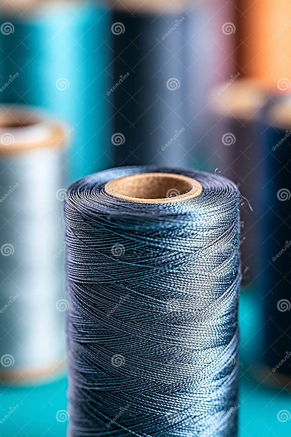 Close-Up of Blue Thread Spool with Colorful Blurred Spools in ...