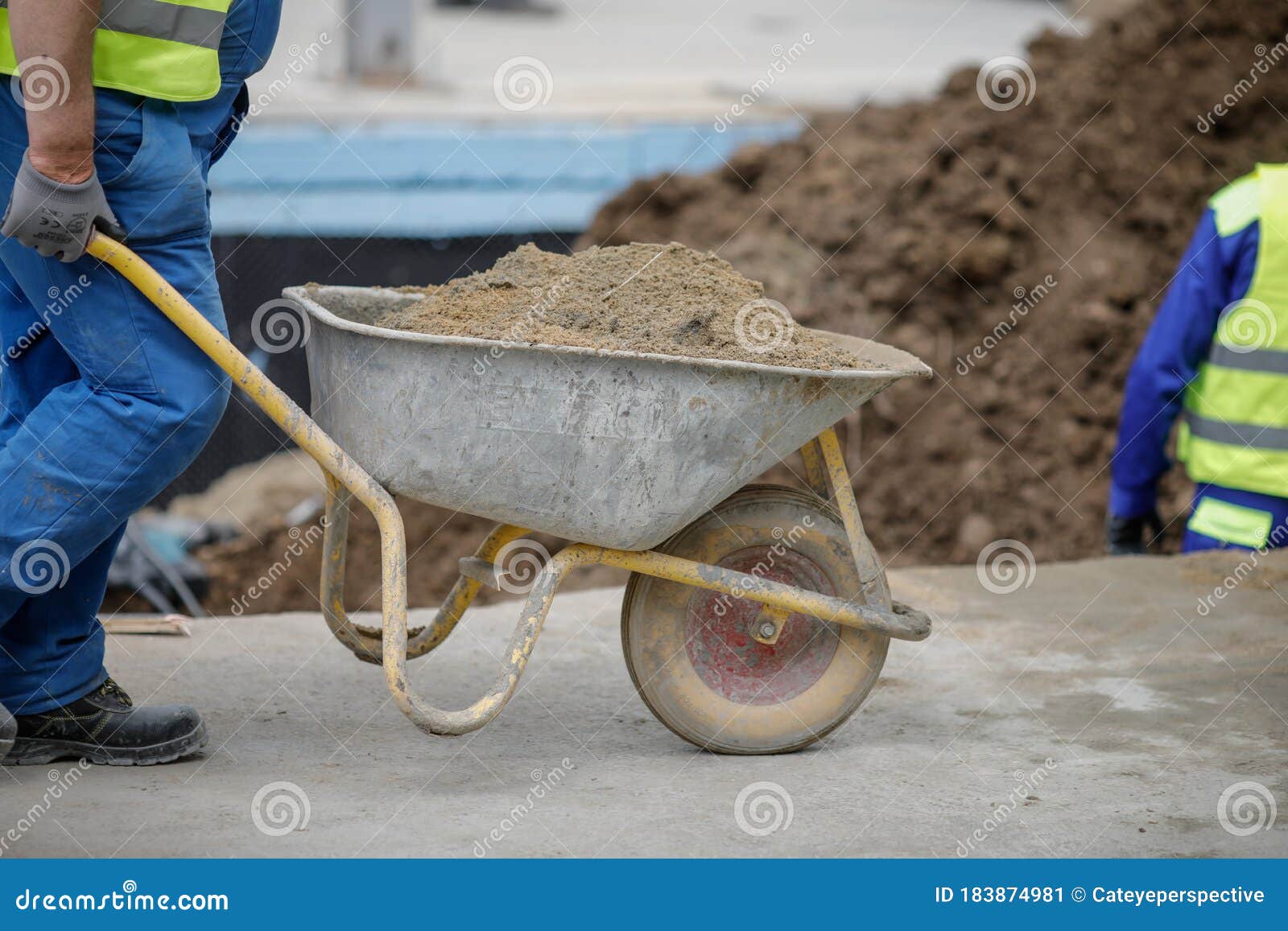 Details with a Construction Worker Pushing a Wheelbarrow on a ...