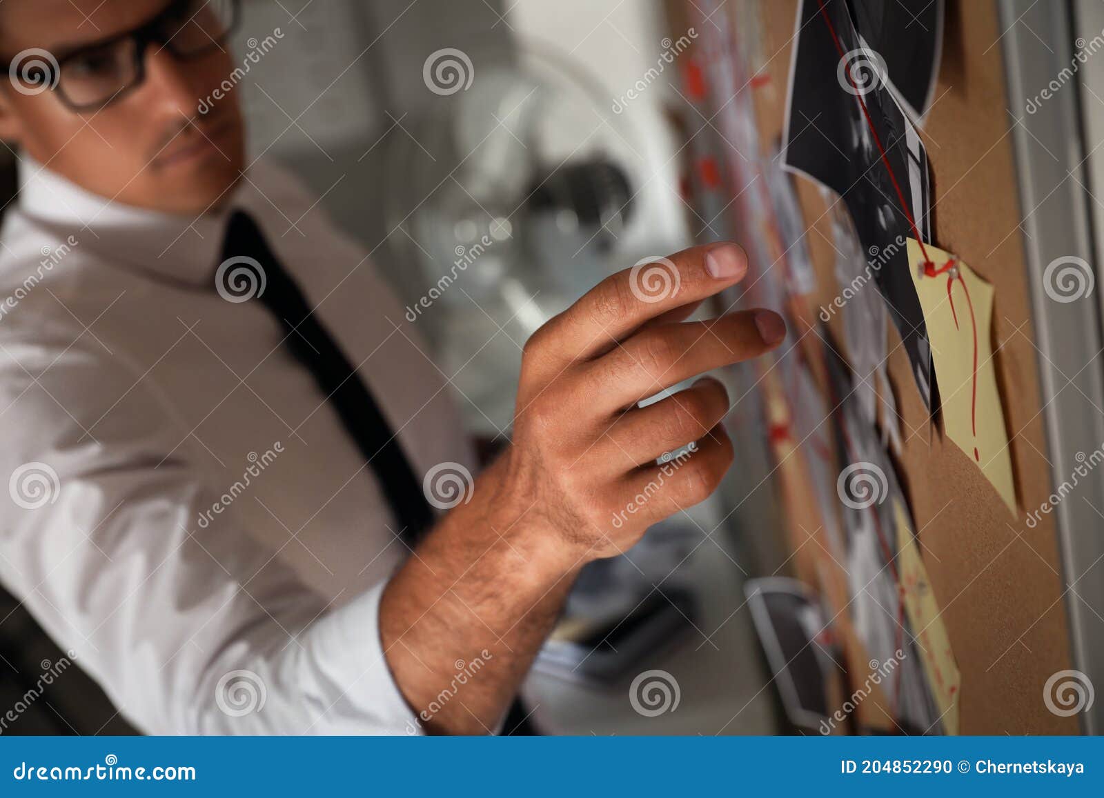 Detective Looking at Evidence Board in Office, Focus on Hand Stock ...