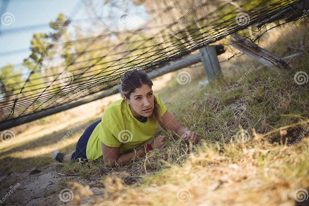Determined Woman Crawling Under the Net during Obstacle Course Stock ...