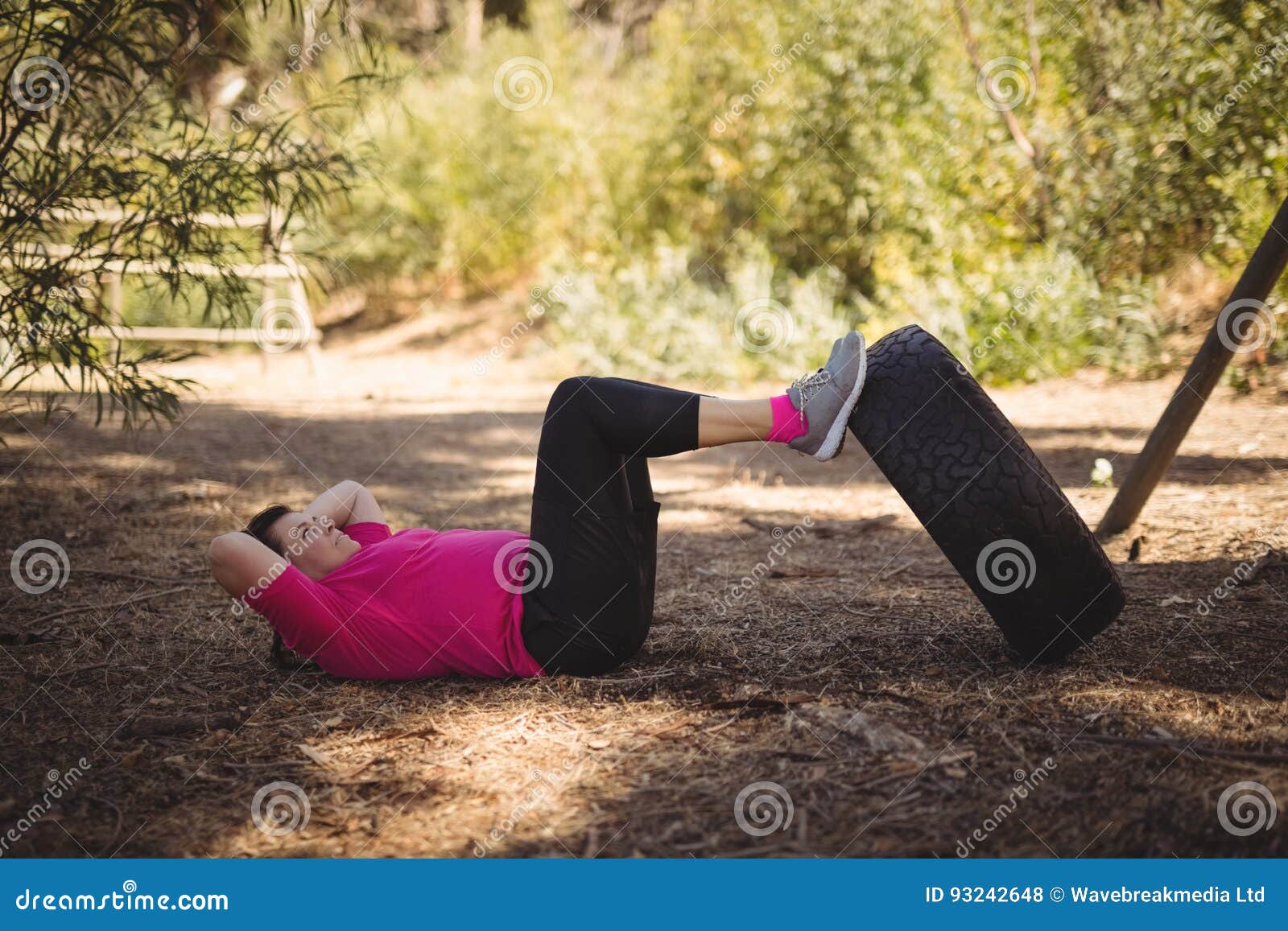 Determined Woman Exercising with Huge Tyre during Obstacle Course Stock ...
