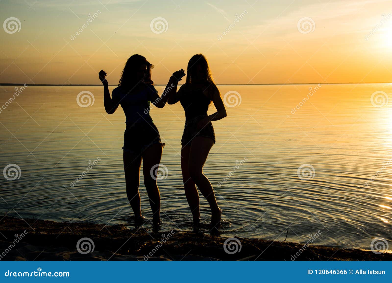 Deux Belles Filles Dansent Tenant Des Mains Sur La Plage Au Su Photo