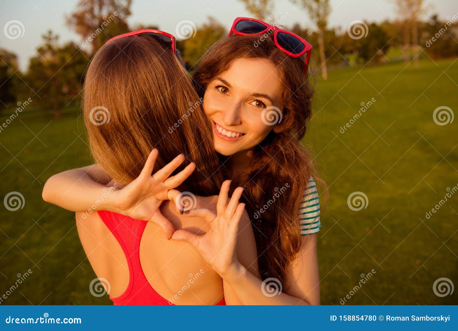 Deux Jeunes Filles Adorables Se Tenant Les Unes Les Autres Et Montrant