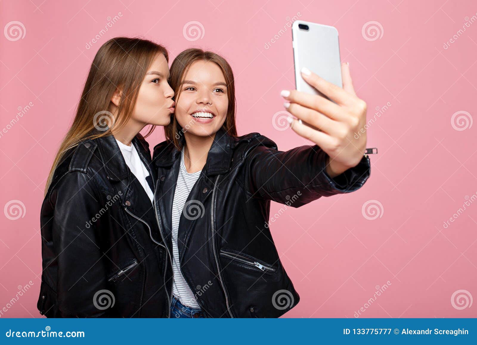 Deux Jeunes Soeurs Jumelles Magnifiques Dans Des Vestes En Cuir Avec Le