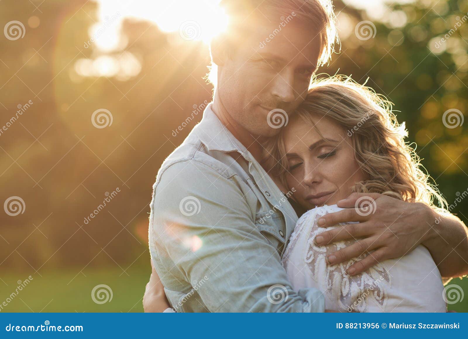 Devoted Young Couple Hugging Under the Setting Sun Stock Photo - Image ...