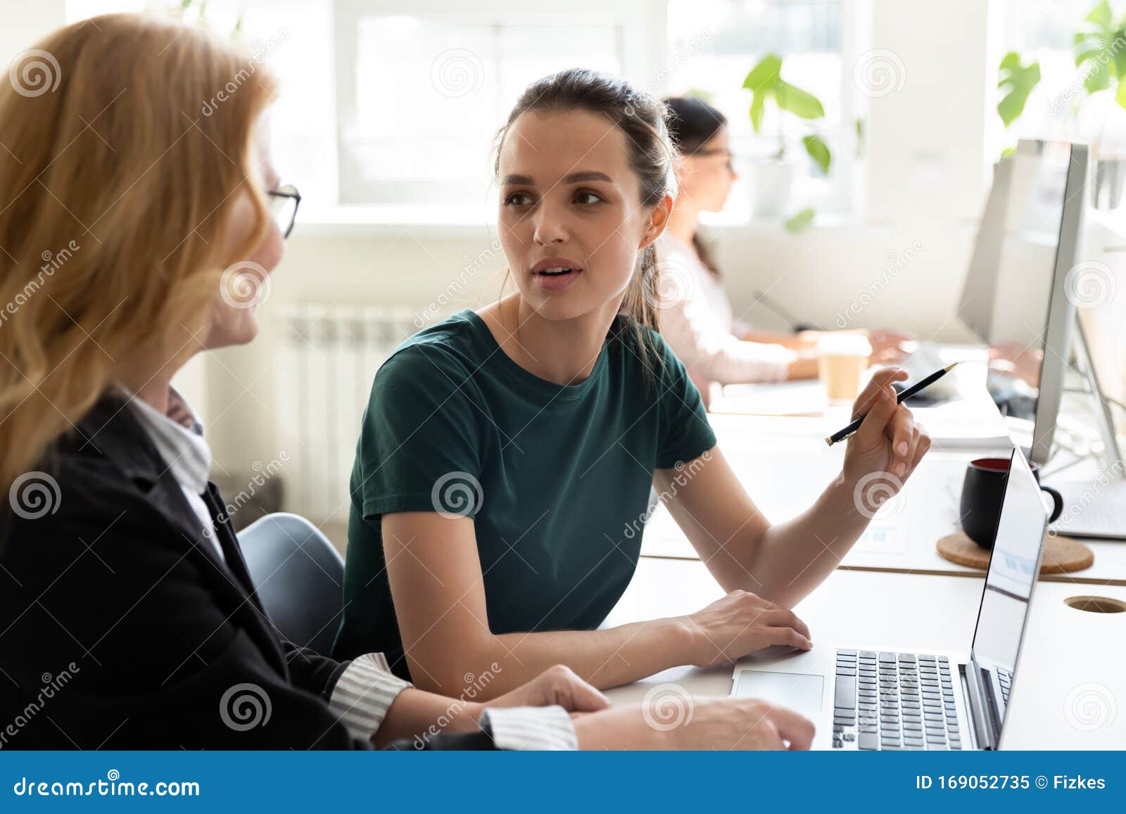Different Age Female Teammates Working Together on New Project Indoors ...