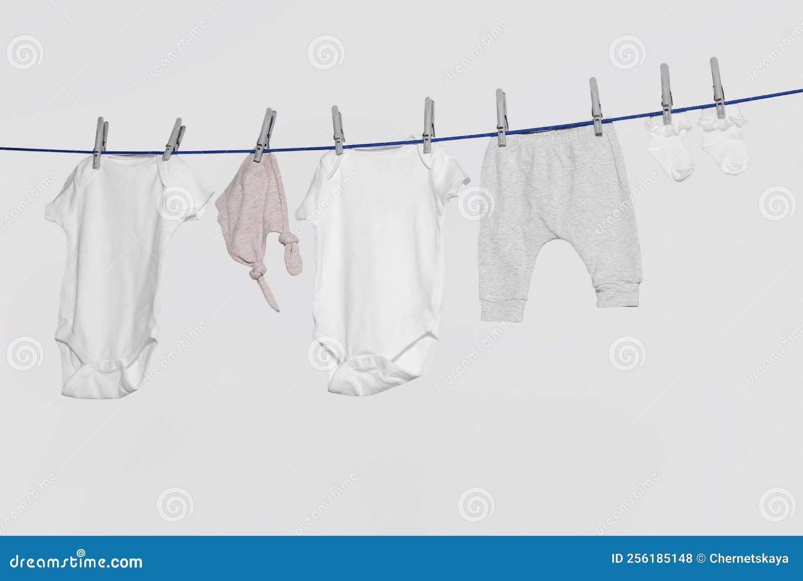 Different Baby Clothes Drying on Laundry Line Against Light Background ...