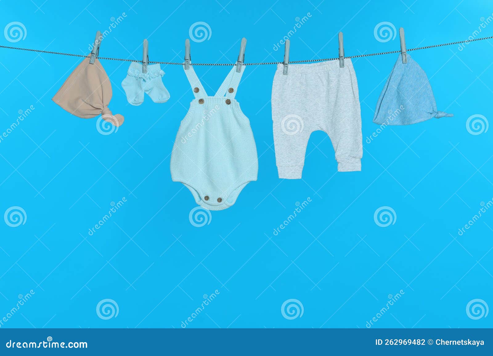 Different Baby Clothes Drying on Laundry Line Against Light Blue ...