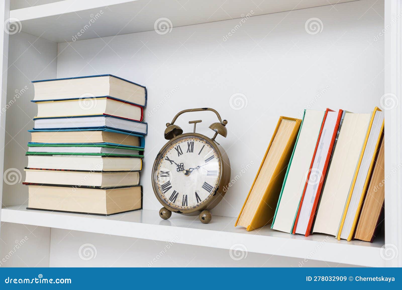 Different Books and Alarm Clock on Shelving Unit Stock Image - Image of ...
