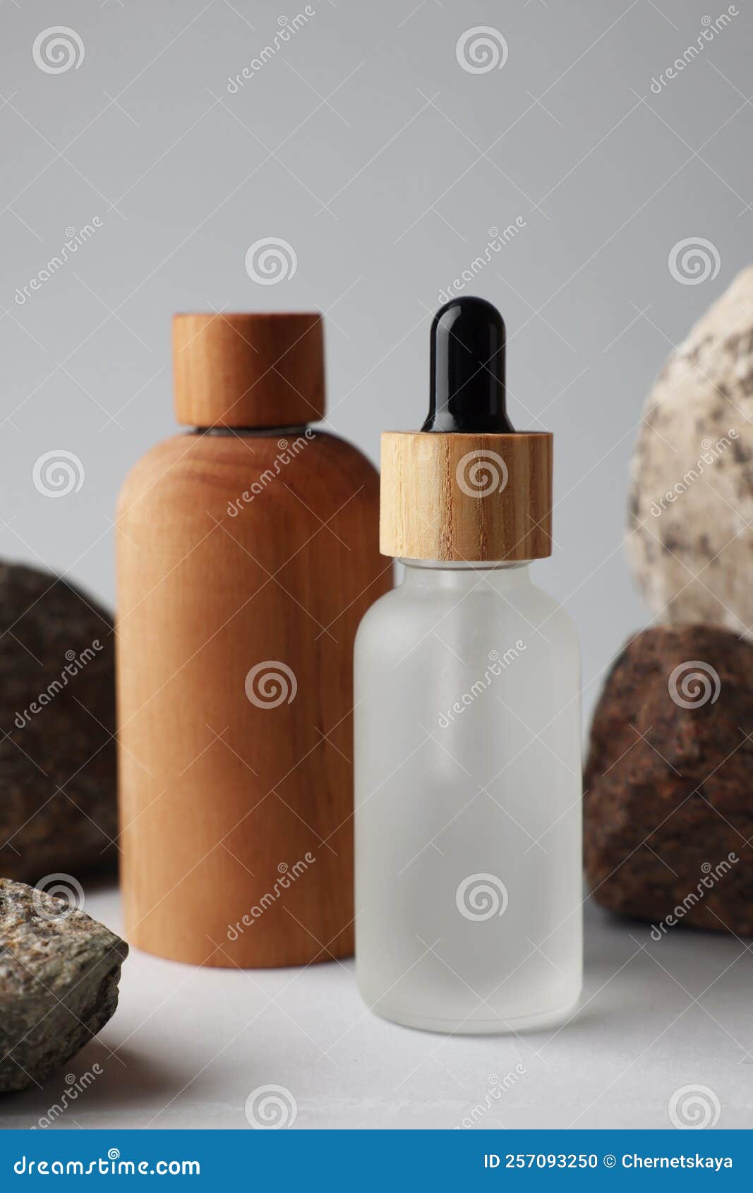 Different Bottles and Stones on Grey Background, Closeup Stock Photo ...