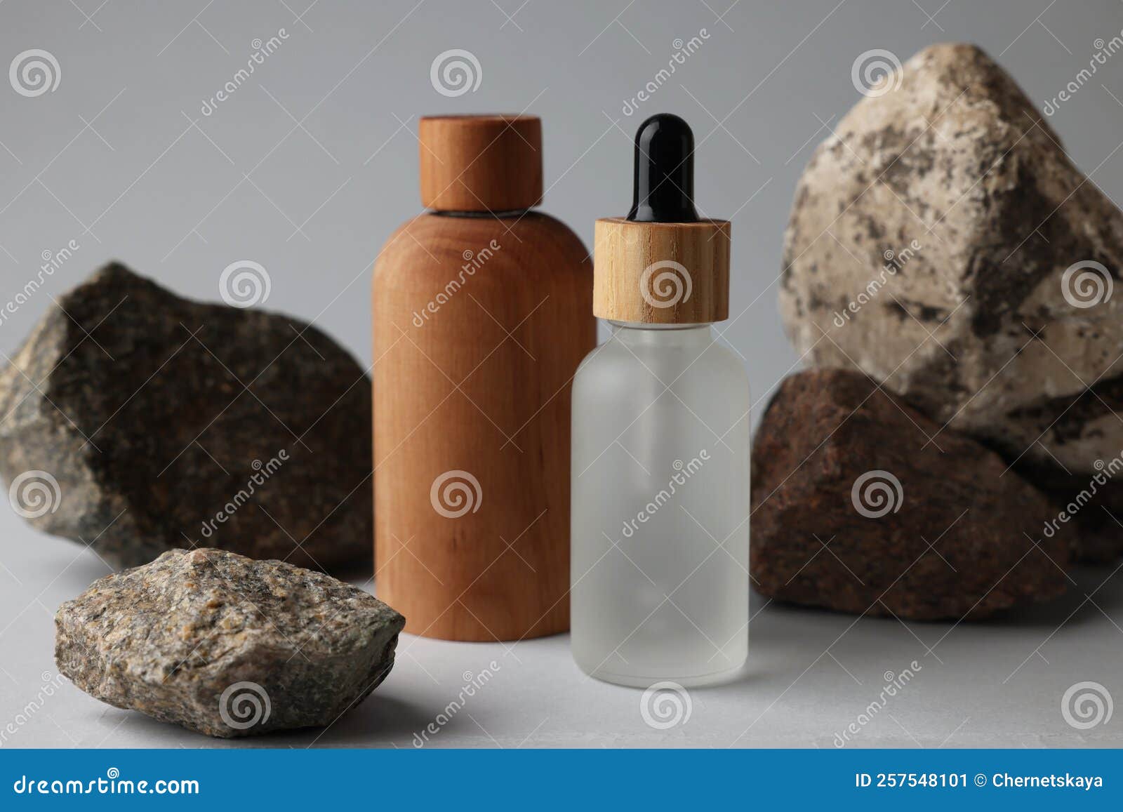Different Bottles and Stones on Grey Background, Closeup Stock Image ...