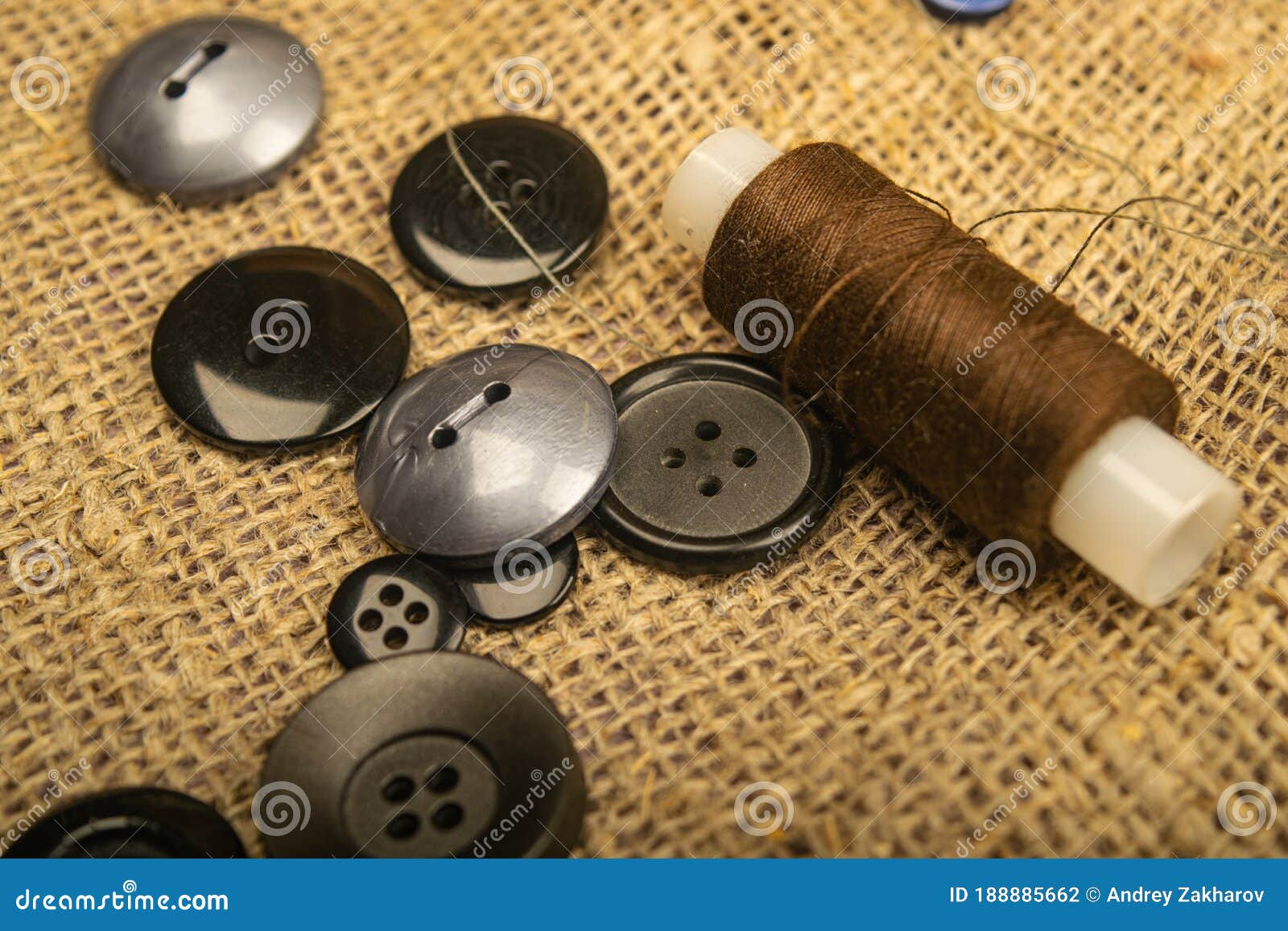 Different Buttons and a Spool of Thread on the Burlap with a Rough ...