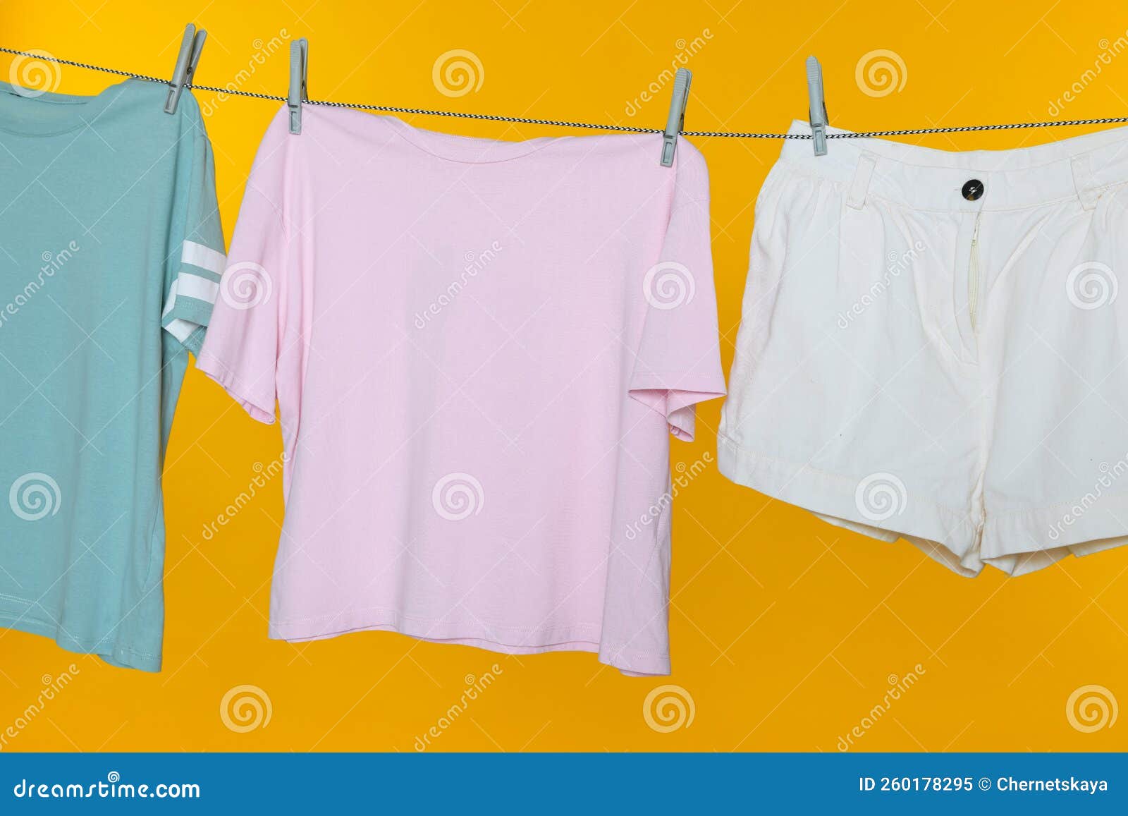 Different Clothes Drying on Laundry Line Against Orange Background ...