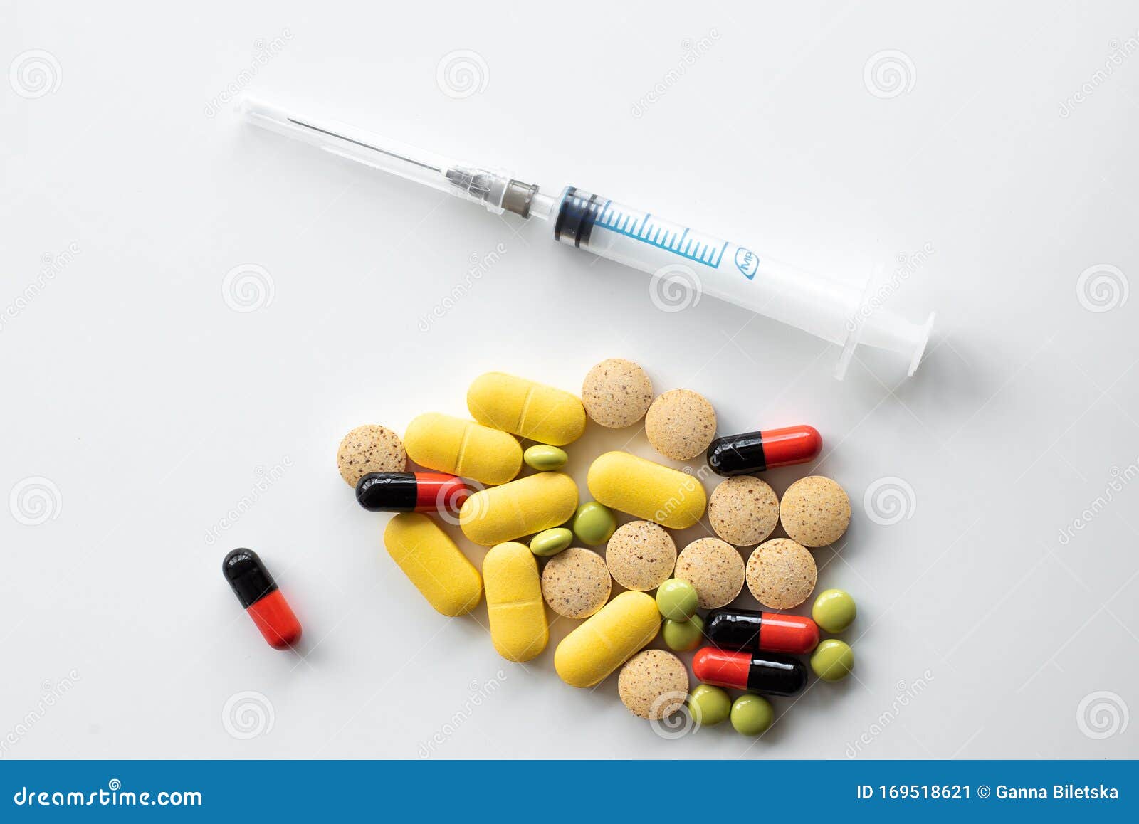 Different Colored Pills and Capsules of Different Shapes and a Syringe ...