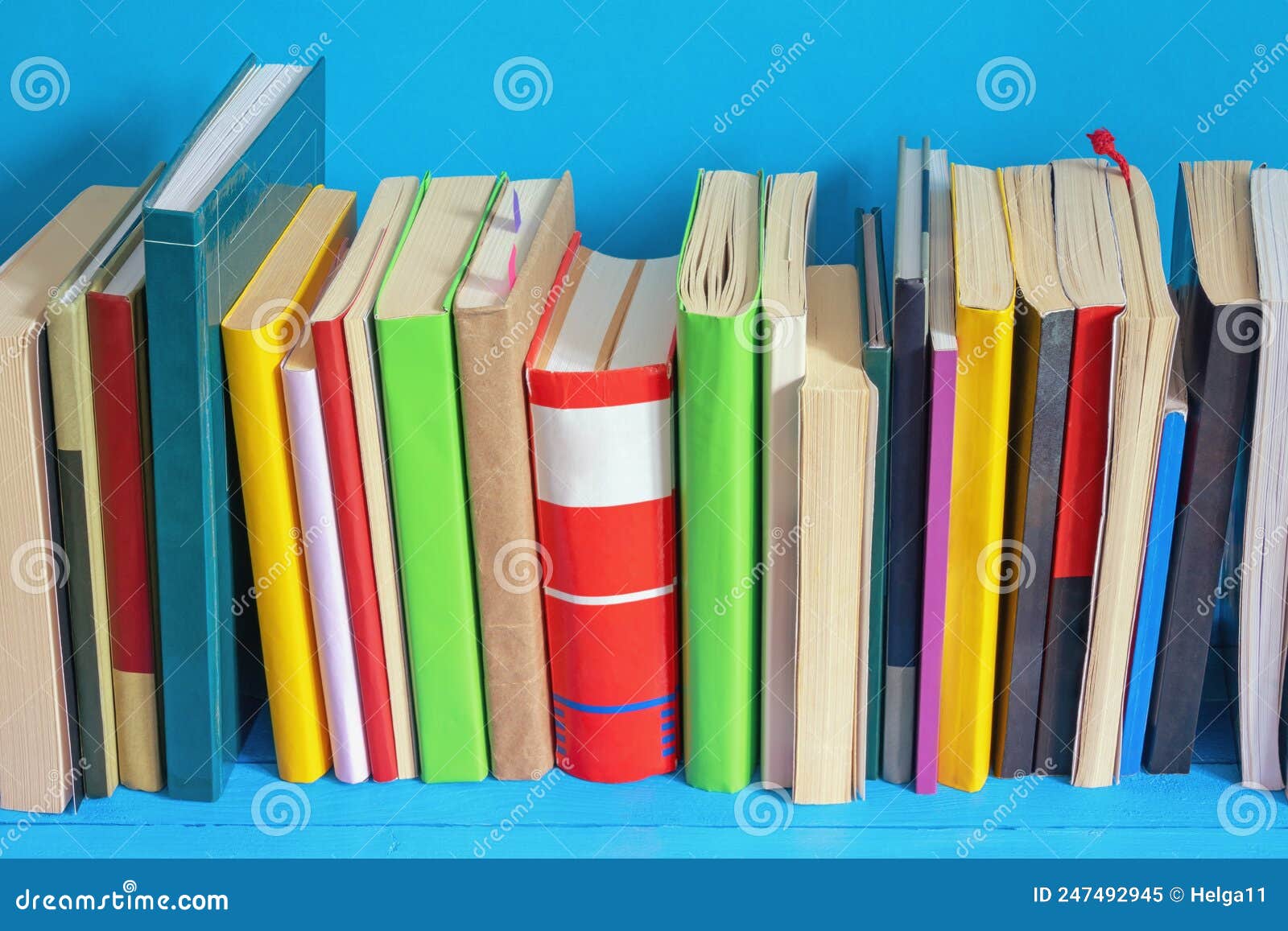Different Colorful Books on Blue Bookshelf. Copy Space Stock Image ...