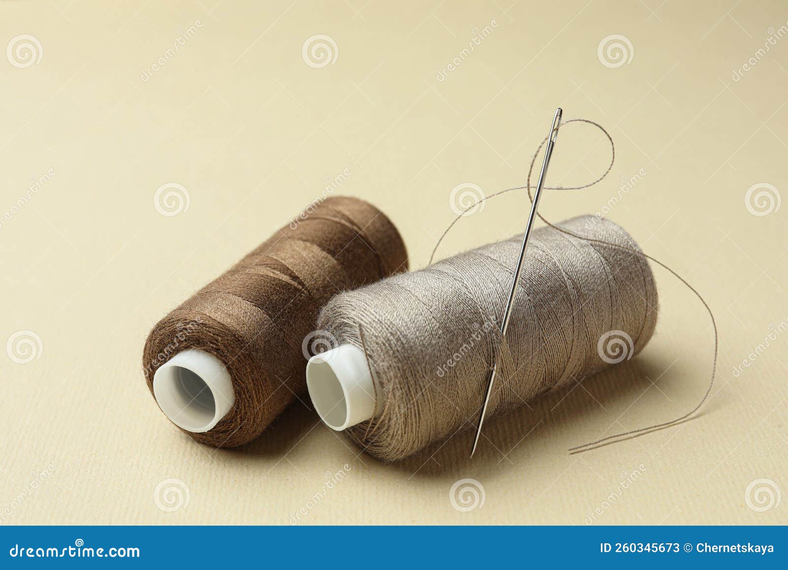 Different Colorful Sewing Threads with Needle on Beige Background Stock ...