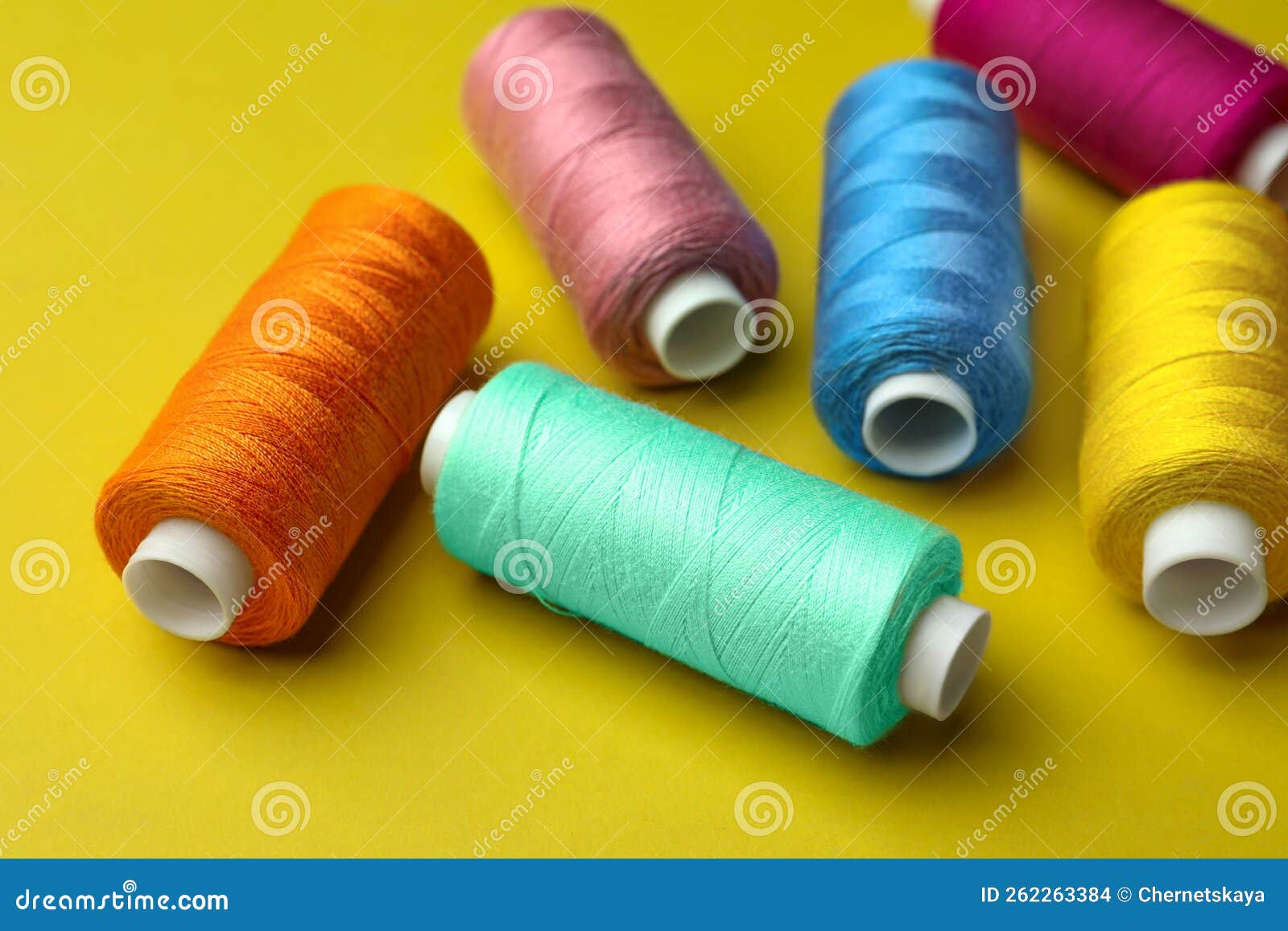 Different Colorful Sewing Threads on Yellow Background Stock Photo ...
