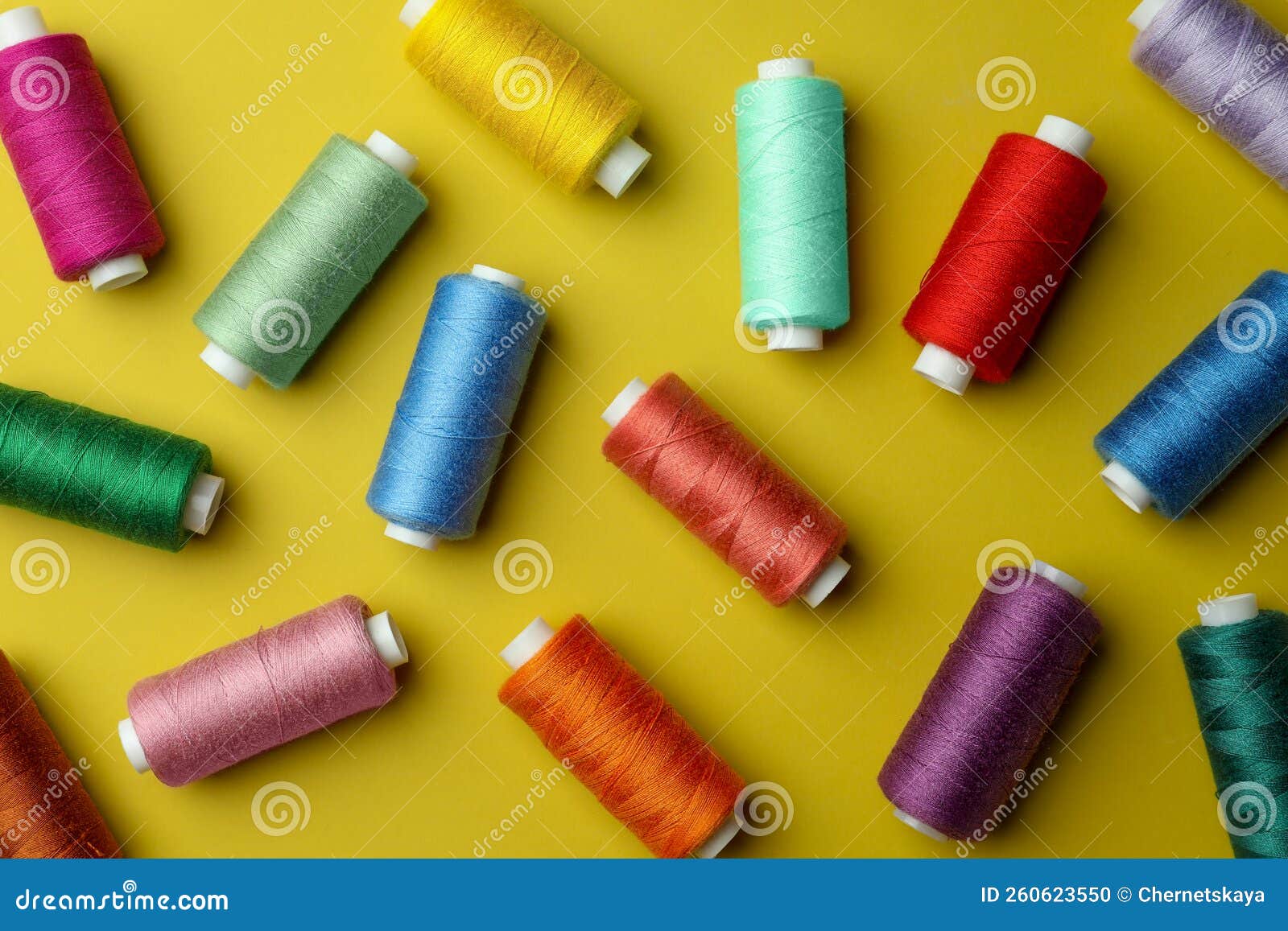 Different Colorful Sewing Threads on Yellow Background, Flat Lay Stock ...
