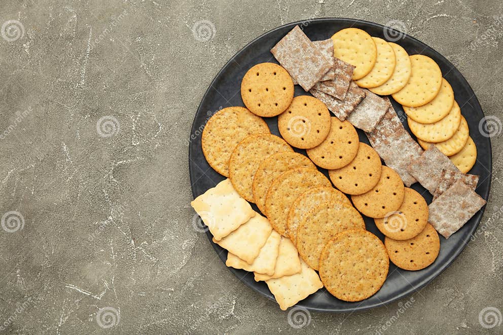 Different Crackers on Plate on Grey Concrete Background Stock Photo ...