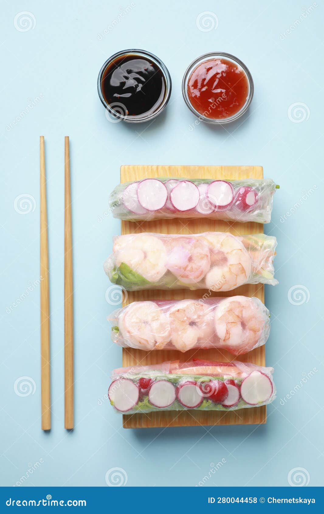 Different Delicious Spring Rolls, Chopsticks and Sauces on Light Blue ...