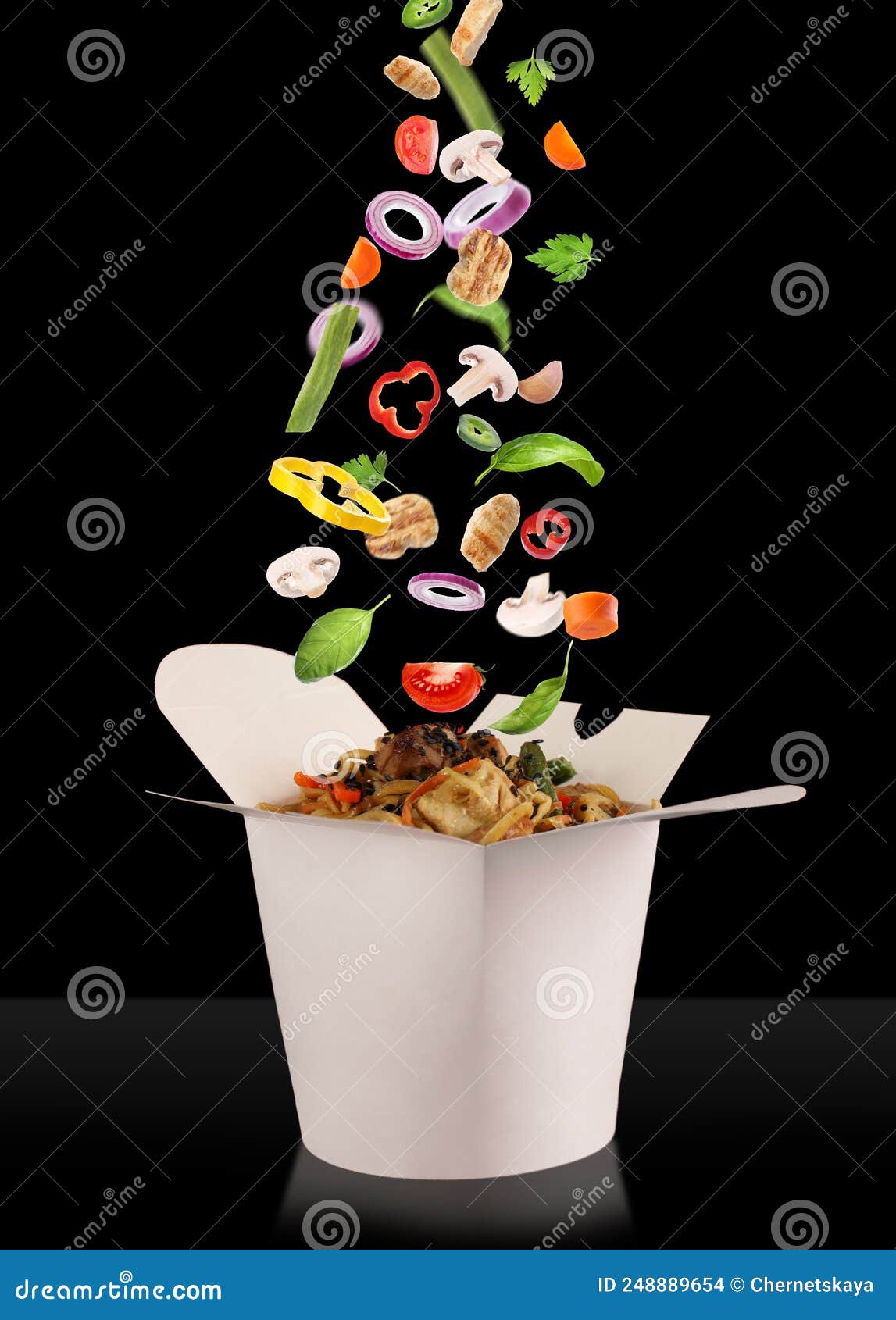 DIfferent Fresh Ingredients Falling into Box of Wok Noodles on Black ...