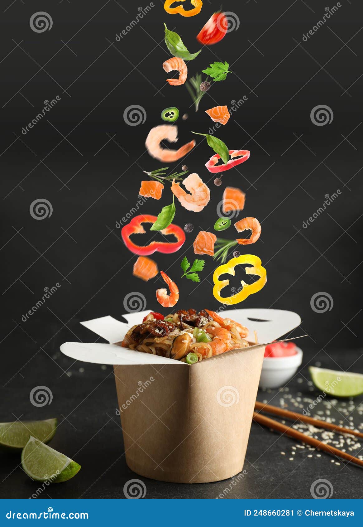 DIfferent Fresh Ingredients Falling into Box of Wok Noodles on Black ...