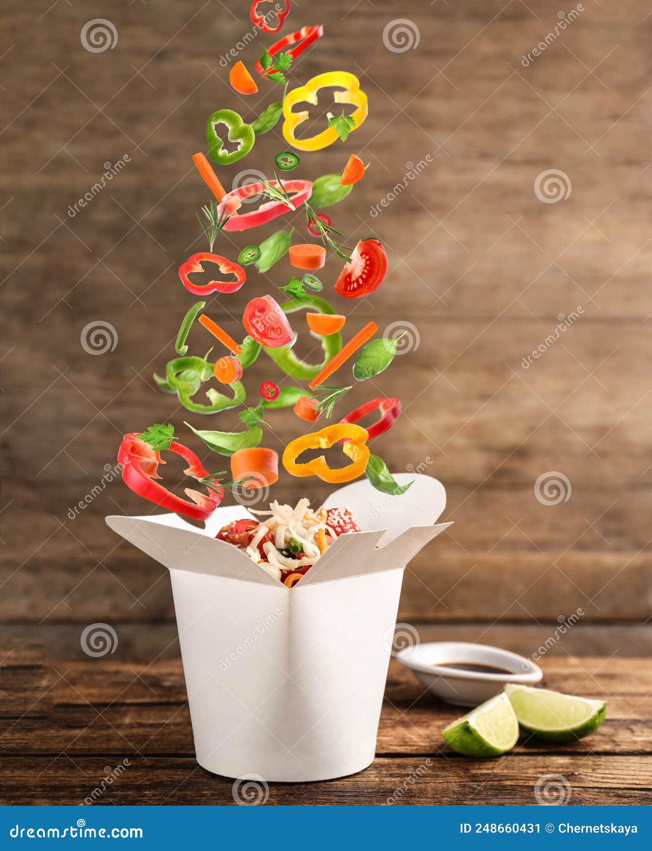 DIfferent Fresh Ingredients Falling into Box of Wok Noodles on Wooden ...