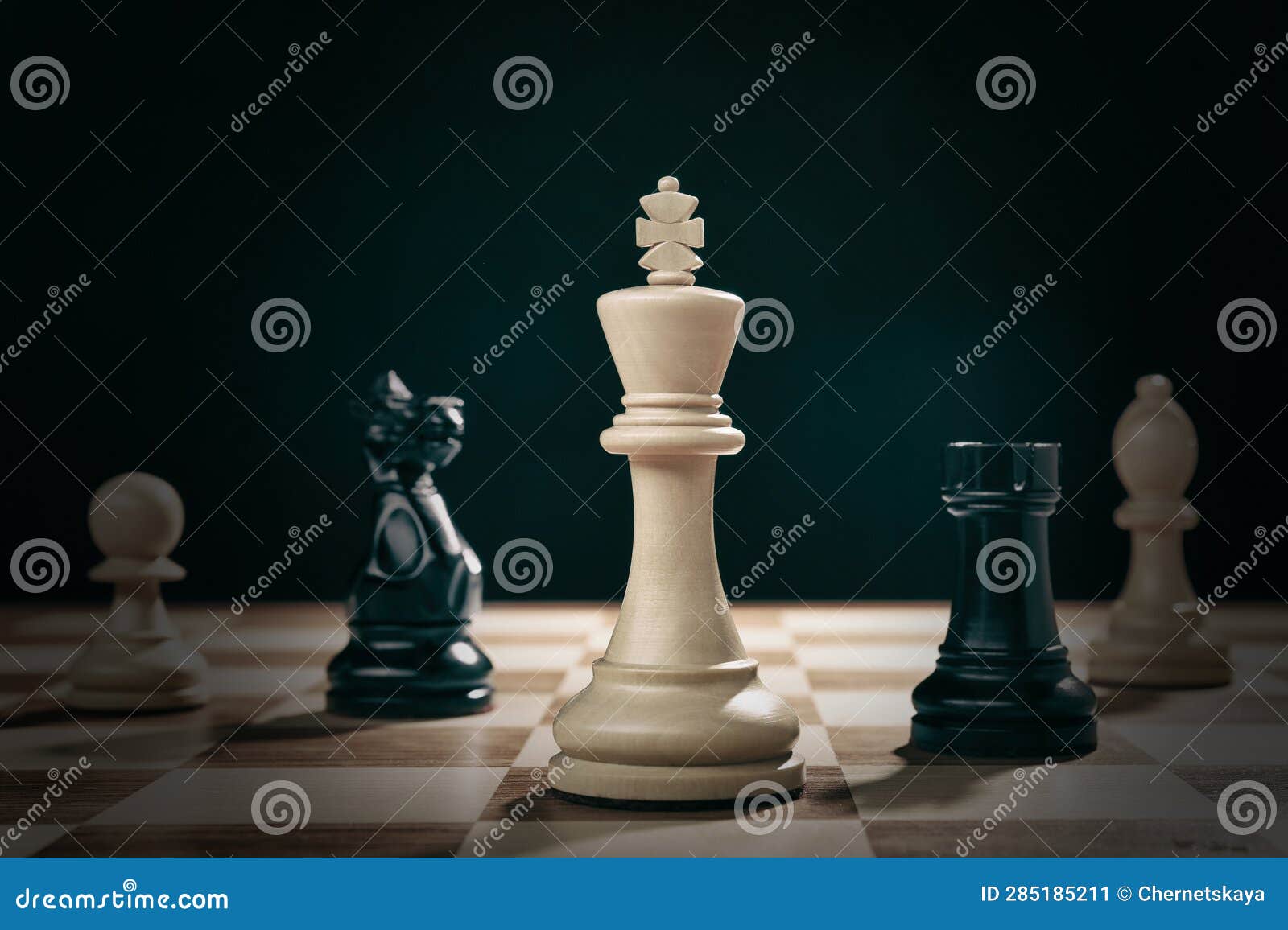 Different Game Pieces on Chessboard Against Dark Background Stock Image ...