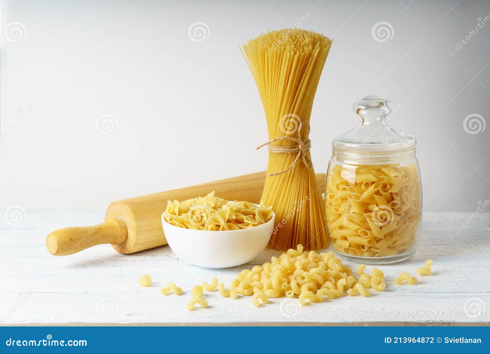 Dry Raw Yellow Pasta and Spaghetti Bunch on White Wood Table Stock ...