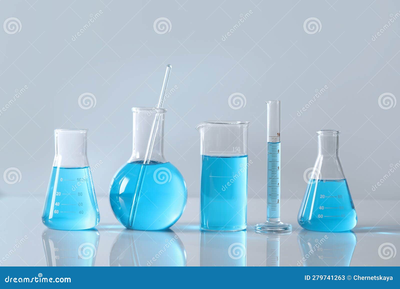 Different Laboratory Glassware with Light Blue Liquid on Table Stock ...