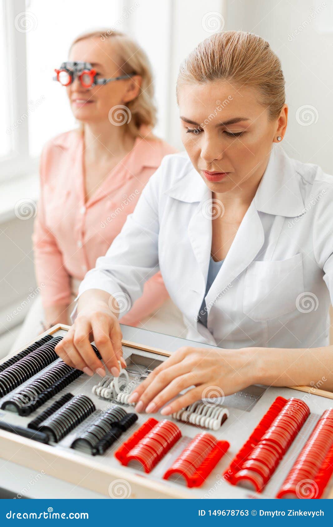 Serious Good-looking Doctor in White Robe Going through Her Collection ...