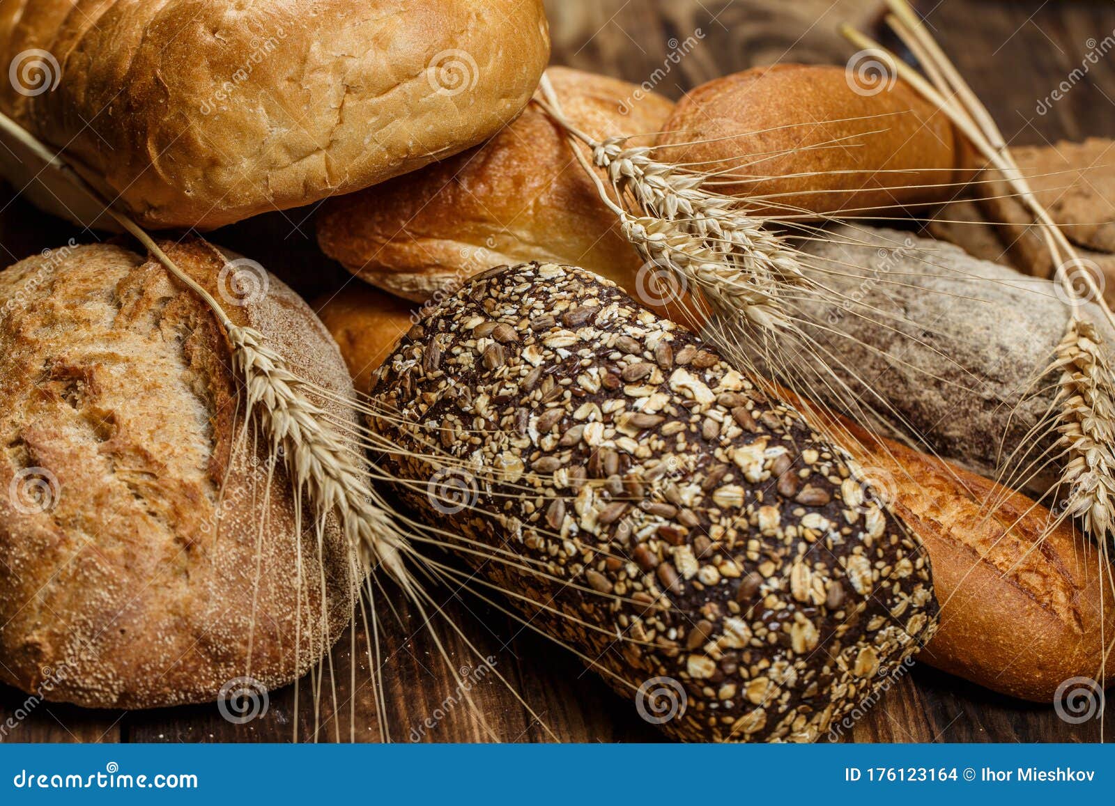 Different Loaves of Bread and Rolls with Wheat and Flour on a Wooden ...